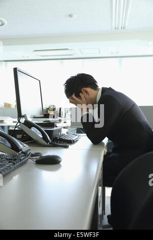 Japanese young businessman depressed at his office desk Stock Photo - Alamy