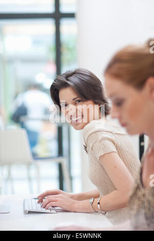 Female office worker using computer in office cubicle Stock Photo - Alamy