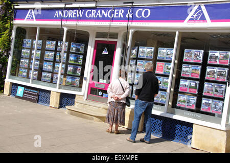 A man looking into a real estate agents shop window to view properties ...