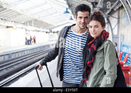 Couple of tourists with luggage on color background Stock Photo - Alamy