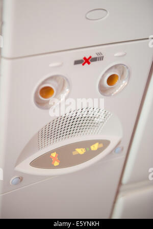 A close up of the overhead panel of a commercial airplane, with ...