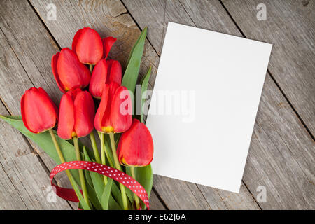 Fresh tulips bouquet and blank card for copy space over wooden table ...