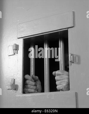 Abstract. Hands of the prisoner on a steel lattice close up. Prison ...