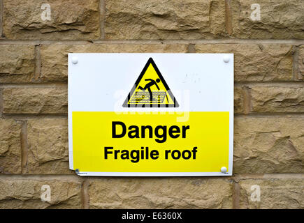 Danger fragile roof sign on the brick wall / building Stock Photo - Alamy