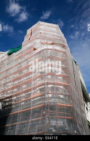 Building exterior with scaffolding undergoing construction and ...