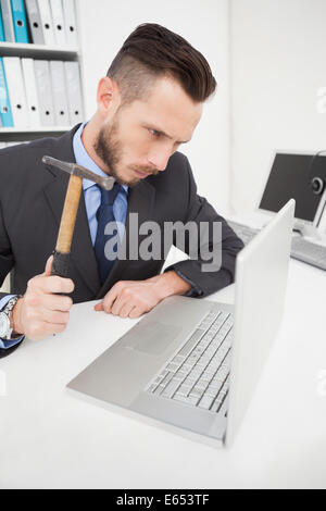 Angry businessman holding hammer over laptop Stock Photo - Alamy
