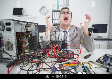 Stressed technician working on broken server Stock Photo - Alamy