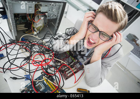 Stressed technician working on broken server Stock Photo - Alamy