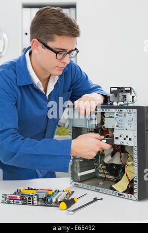 a young technician working on broken computer in his office Stock Photo ...
