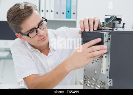a young technician working on broken computer in his office Stock Photo ...