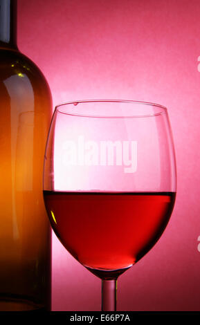 Glass and bottle of rose wine over a yellow background Stock Photo - Alamy