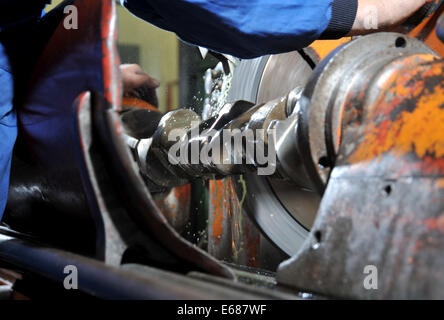 Precision grinding a car engine crankshaft on a crank grinding machine ...