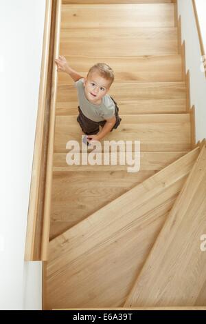 Child going up the staircases at home. One little boy climbing stairs ...