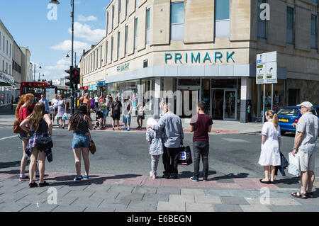 Shoppers crossing the road outside of Primark in Cheltenham town centre ...