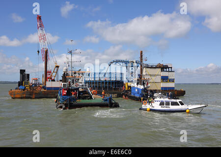 Offshore marine cable laying operation in the Solent, UK. A barge lays ...