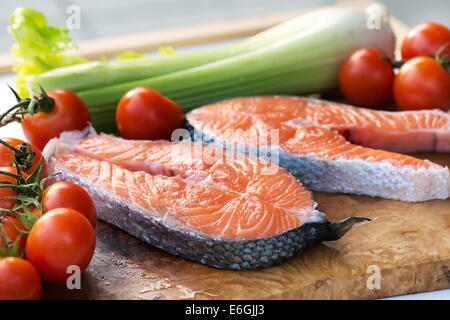 Raw salmon steaks and ingredients on a black slate board Stock Photo ...
