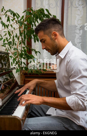 male musician playing an upright piano Stock Photo - Alamy