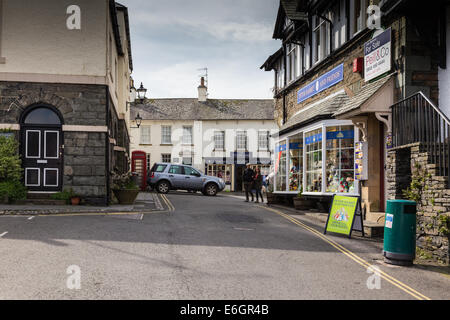 UK, Cumbria, Hawkshead, Main Street, customers sat in sunshine outside ...