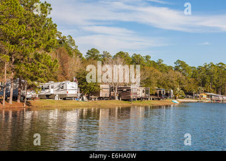 Motorhomes and campers line the lake shore at Flamingo Lake RV Resort ...
