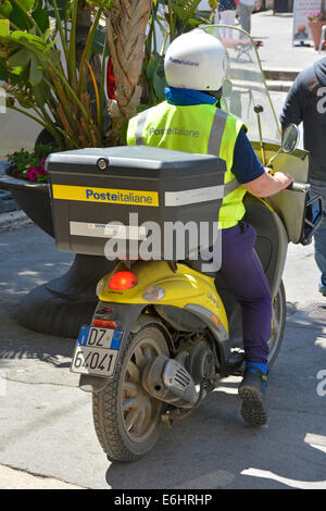 Italian postman on motor bike with large box at rear making deliveries ...