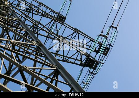 high voltage electric pillar closeup on green field for current supply ...