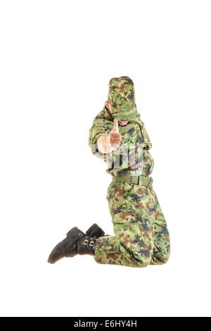 unknown soldier with hidden face in green camouflage uniform kicking ...