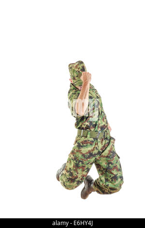 unknown soldier with hidden face in green camouflage uniform kicking ...