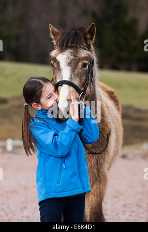 Girl cuddling her pony Stock Photo - Alamy