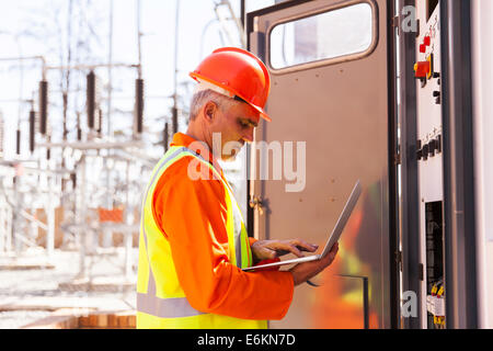 electrician working on laptop computer in control room Stock Photo - Alamy