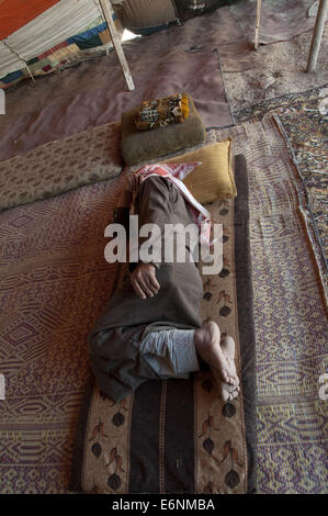 An elderly man takes a nap on a park bench at South Beach, Miami. This ...