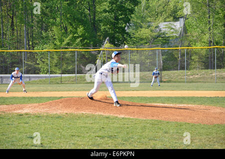 A high school baseball pitcher is pitching from the pitchers mound ...