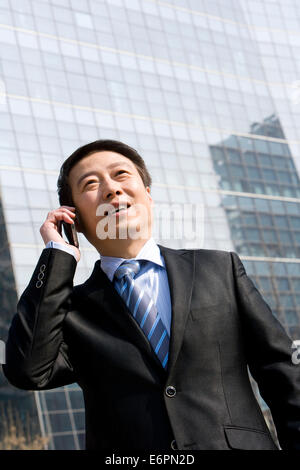 An older Asian man using a phone to photograph native Moorhens ...