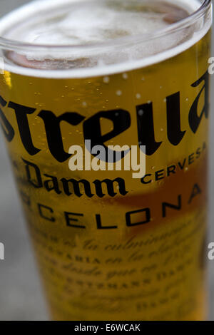Cold glass of Estrella Damm beer on a table outside a restaurant in ...