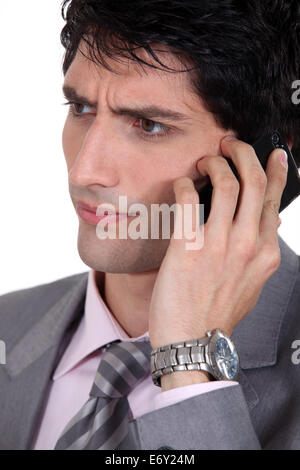 Brunette frowning while using her mobile Stock Photo - Alamy