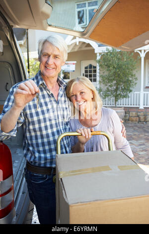 Middle age senior woman moving to a new house packing cardboard boxes ...