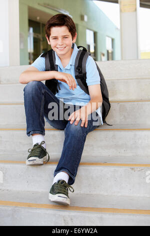 Relaxed teen boy sitting on chair in white studio space Stock Photo - Alamy