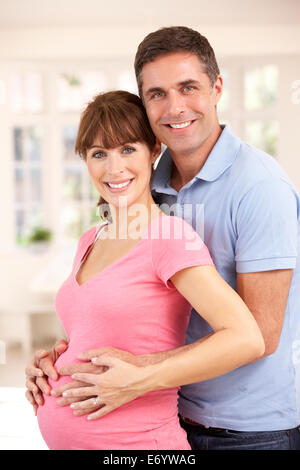 Happy couple expecting a baby, sharing an intimate moment in a ...