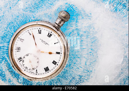 Pocket watch stuck in ice, frozen in time Stock Photo - Alamy