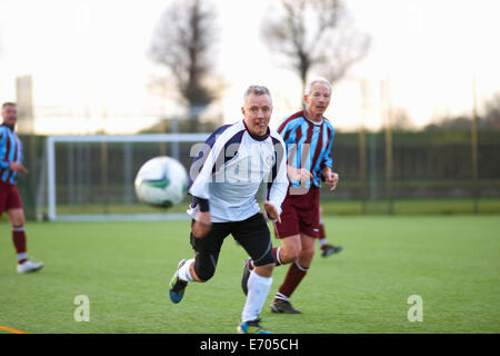 Caucasian football player running with ball Stock Photo - Alamy