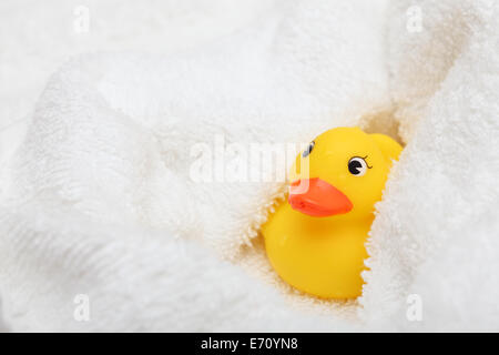 A yellow rubber duck wrapped in red cotton bobble hat and red scarf for ...