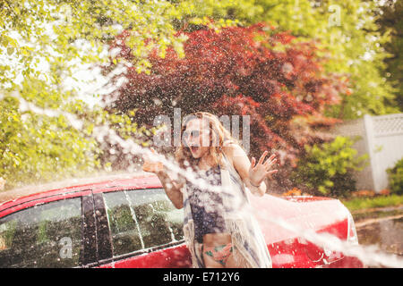 A young woman being sprayed with water Stock Photo - Alamy