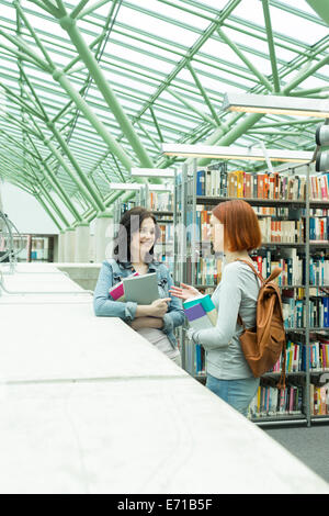 Two students in a university library walking upstairs Stock Photo - Alamy