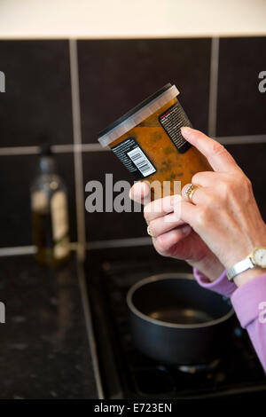 woman reading ingredients label on tub of prepared pasta salad Stock ...