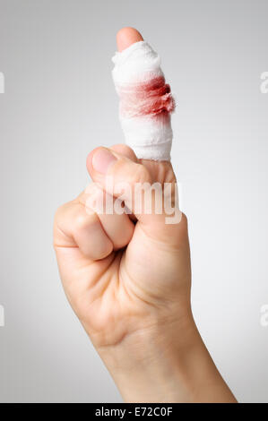 Hand with a finger injury with a white bloody bandage, bandages stained ...