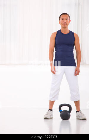 Young Man Exercising With Kettle Bell And Flexing Muscles - Muscular ...