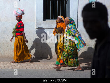 Harari women walking in the street wearing colourful clothing. Harar ...
