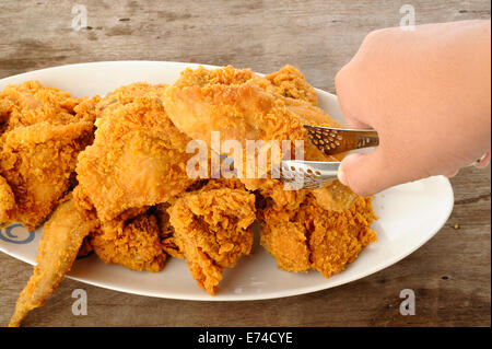 Tongs holding fried chicken Stock Photo - Alamy