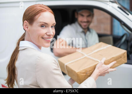 Delivery driver handing parcel to customer in his van Stock Photo - Alamy