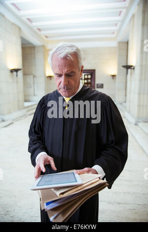 Senior caucasian judge man using gavel puffing cheeks with funny face ...