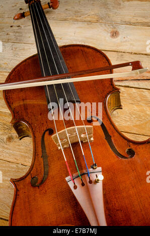 Old viola and arch on a wooden background Stock Photo - Alamy